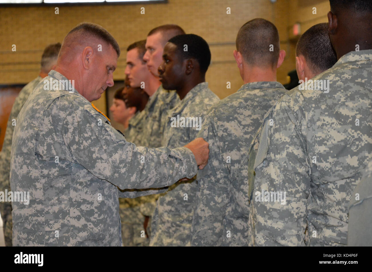 A representative from the 59th Troop Command places the unit patch on a ...