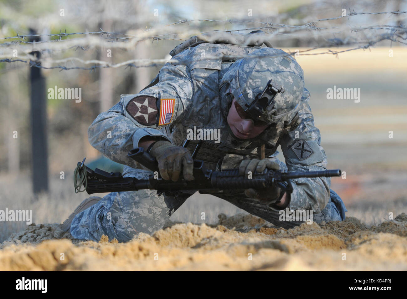 Sgt. Michael Gault, 218th MEB, dives under the barbed wire to low crawl ...
