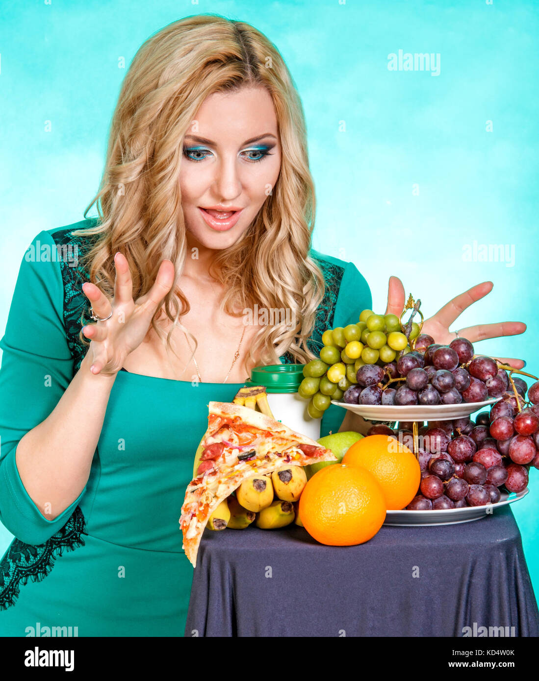 Young woman with a bunch of food over green background Stock Photo - Alamy