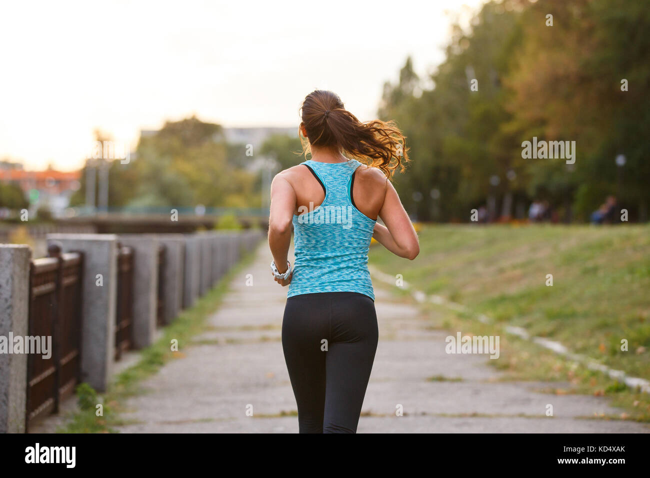 Young sporty woman running in park. Fitness girl jogging in park. Rear ...