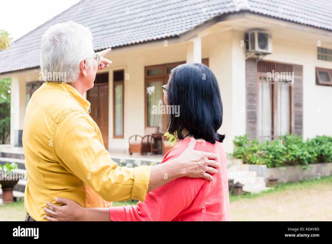 Elderly man pointing to a comfortable residential house while st Stock ...