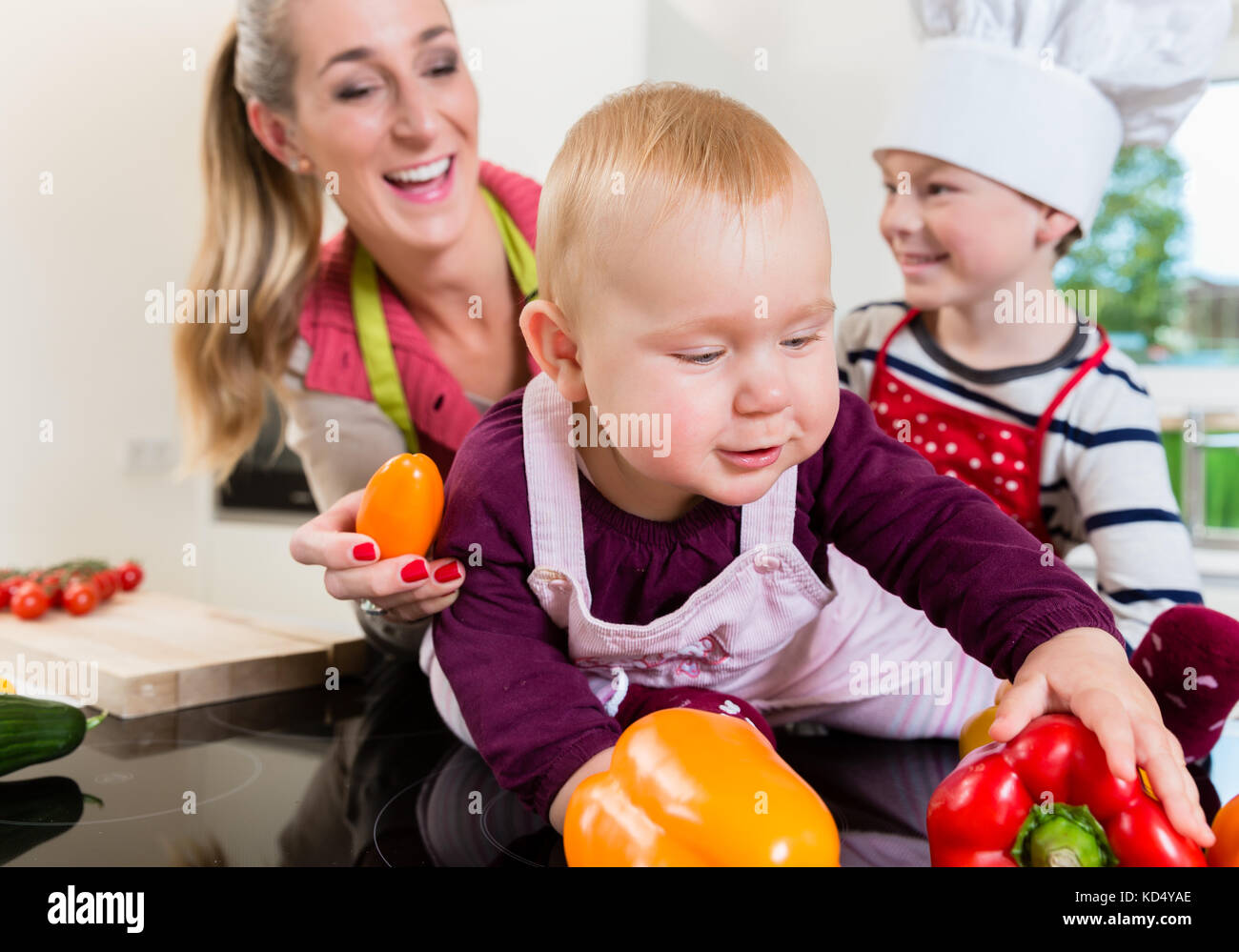 Mum and two children cooking together in kitchen Stock Photo - Alamy