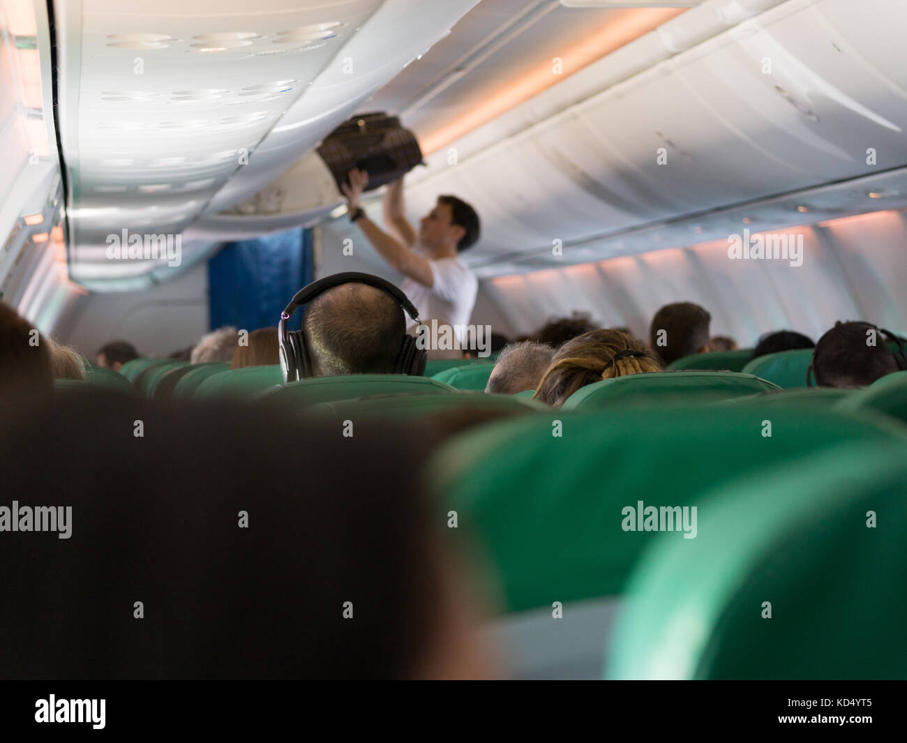 airplane interior - people sitting on seats, wideshot Stock Photo - Alamy