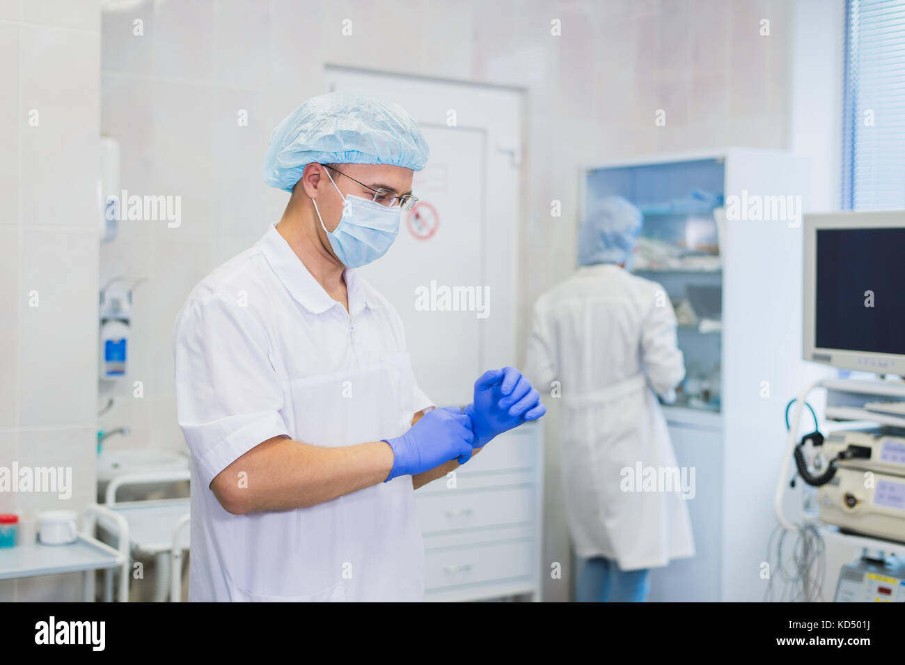 Young man doctor during medical procedure hi-res stock photography and ...