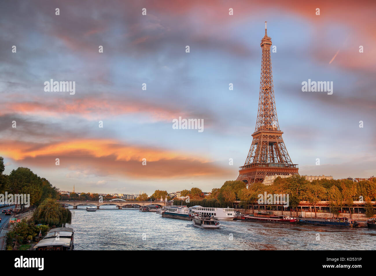Eiffel tower by seine river against blue sky at sunset hi-res stock ...