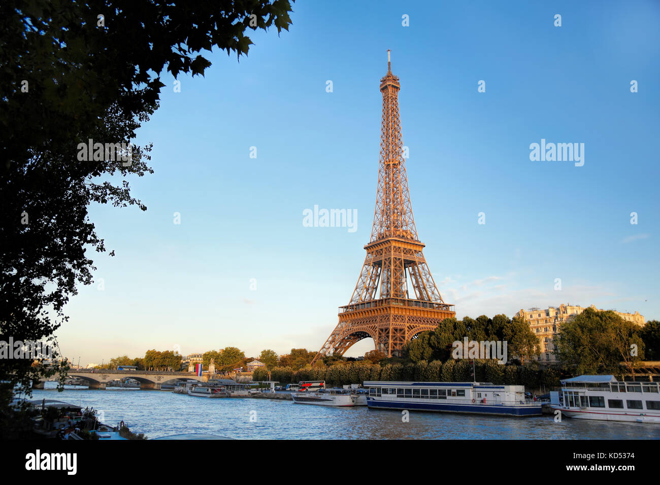 Eiffel tower by seine river against blue sky at sunset hi-res stock ...