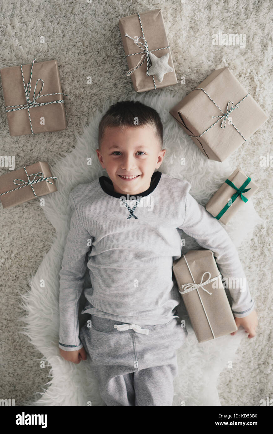 Boy with christmas present lying on back Stock Photo - Alamy