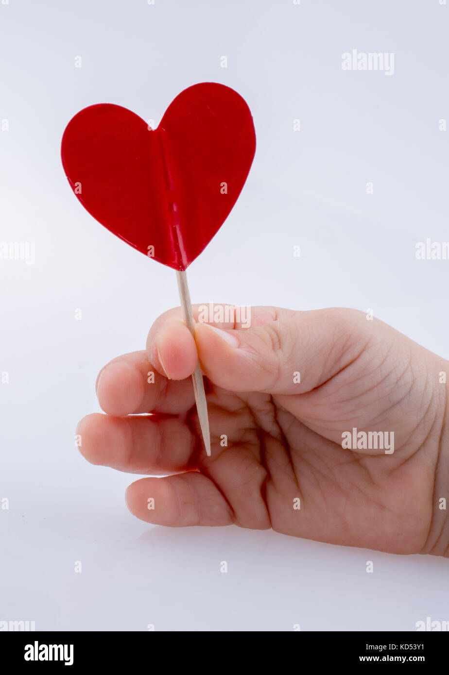 Little red color heart shape at the top of a stick in hand Stock Photo ...