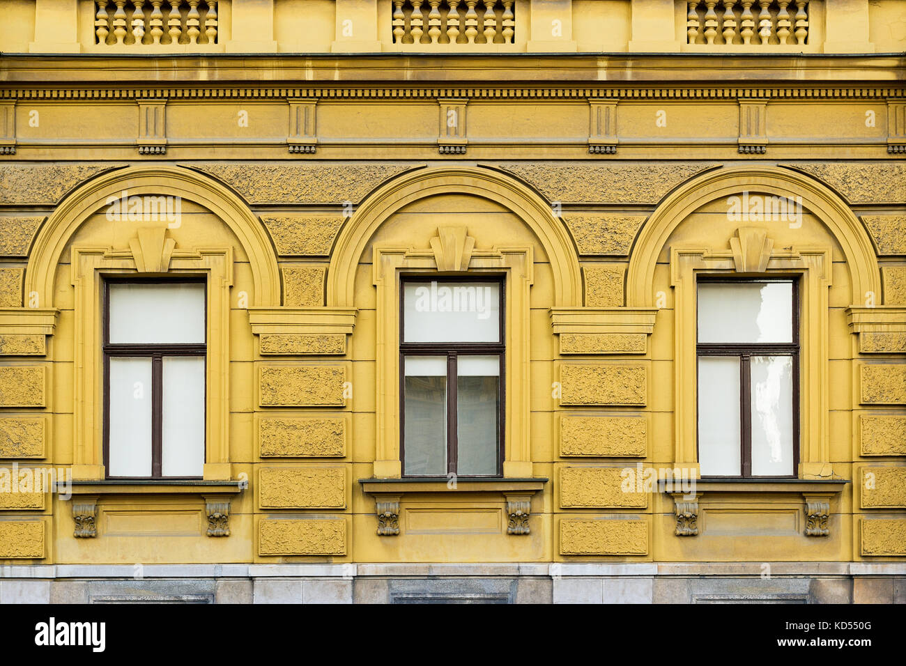 Old decorative building, yellow colored, with tree windows Stock Photo ...