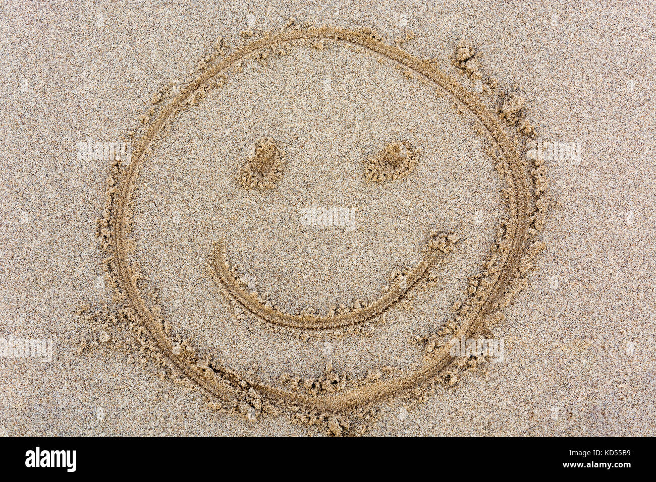 A smiley face drawn in the sand from above Stock Photo - Alamy