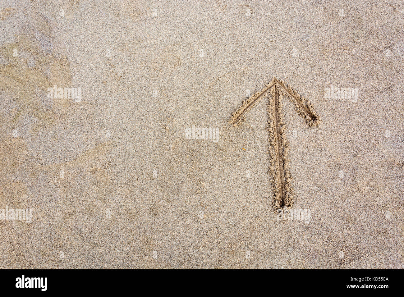 An arrow drawn in the sand from above Stock Photo - Alamy