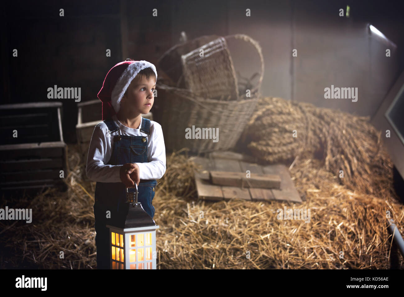 Sweet boy, holding lantern, looking through window, Christmas time in a ...