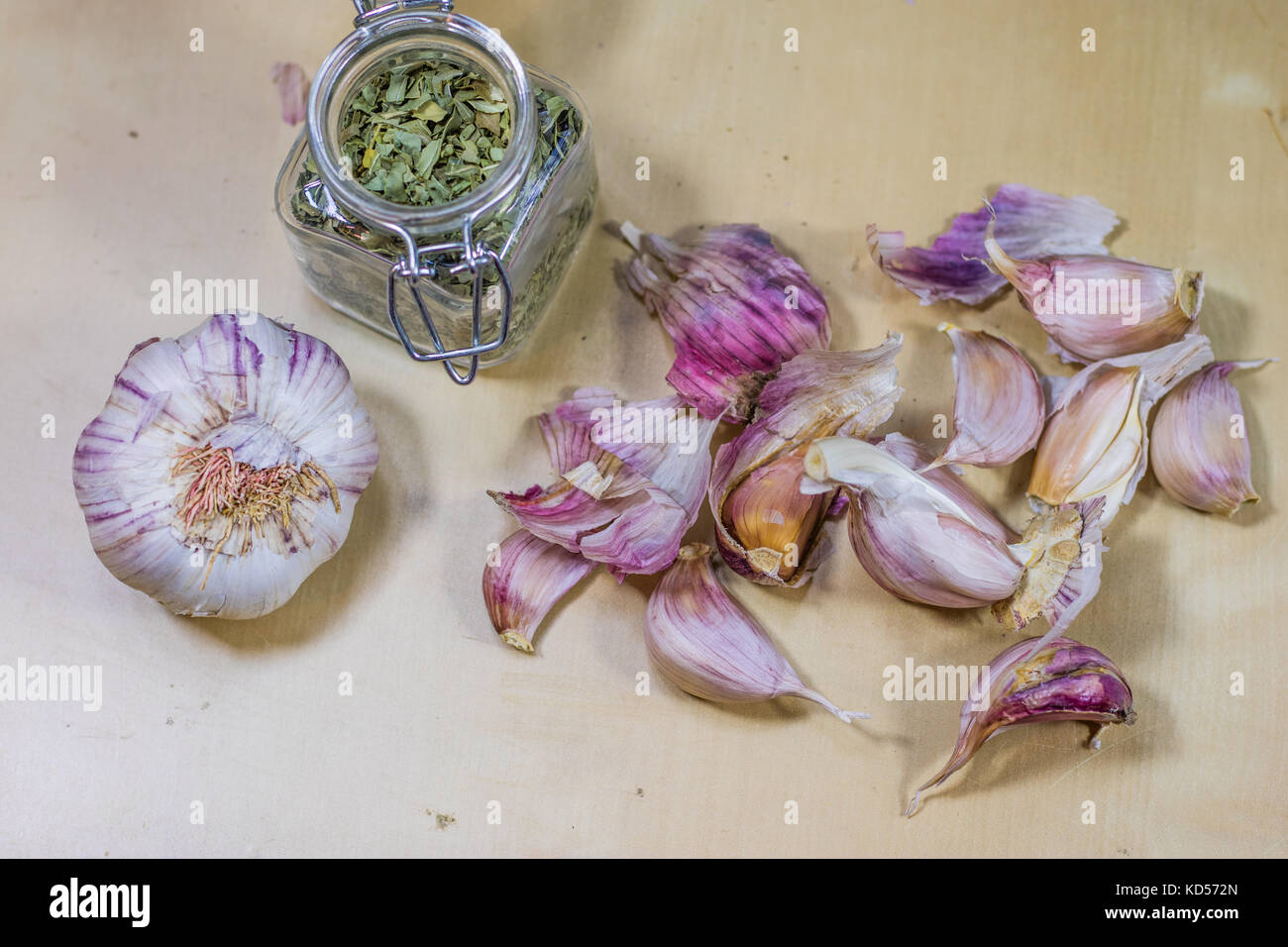 Fresh garlic smelling on the kitchen table. Mortar and kitchenware ...