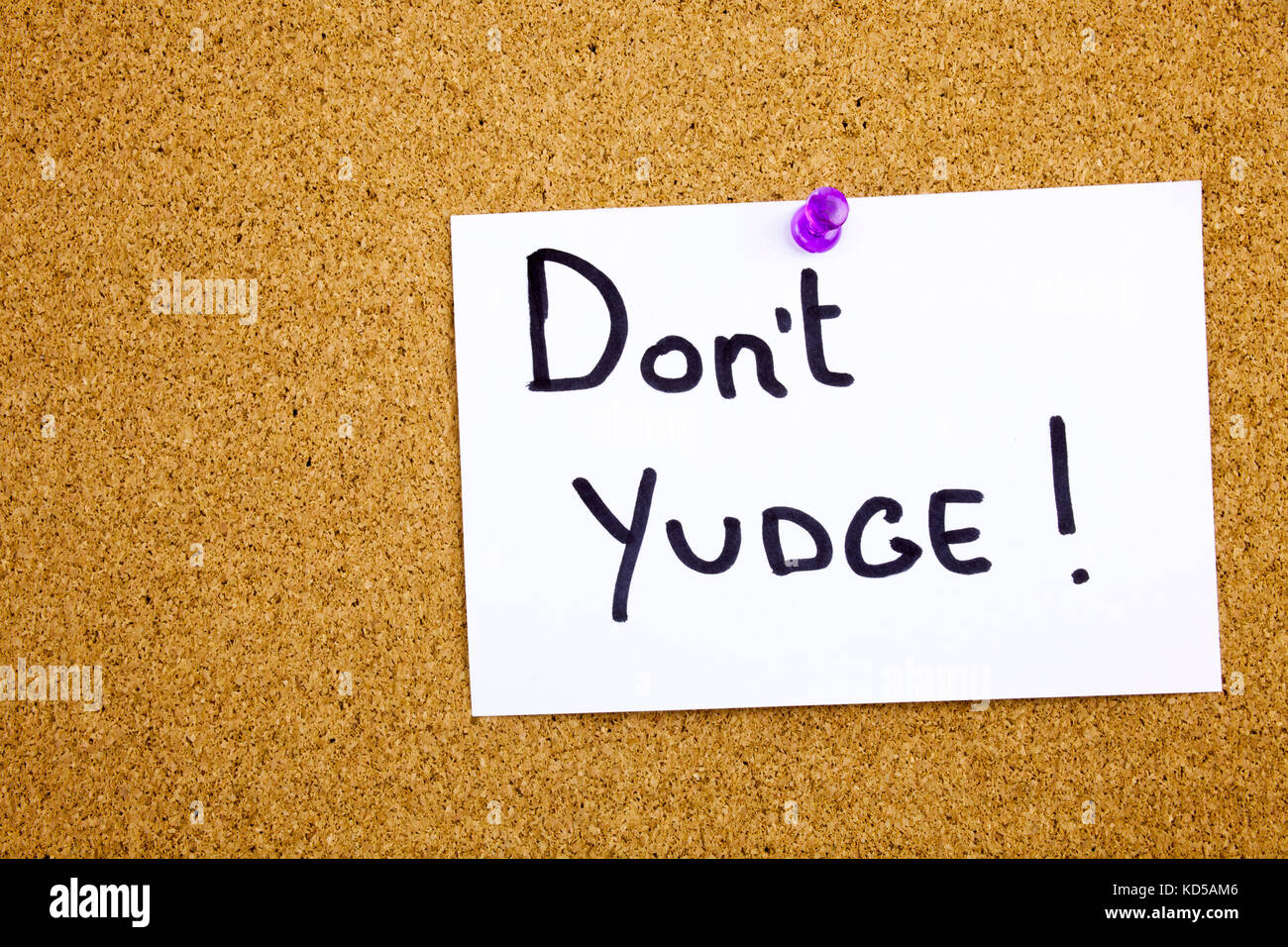 A yellow sticky note writing, caption, inscription Don't Judge placard ...