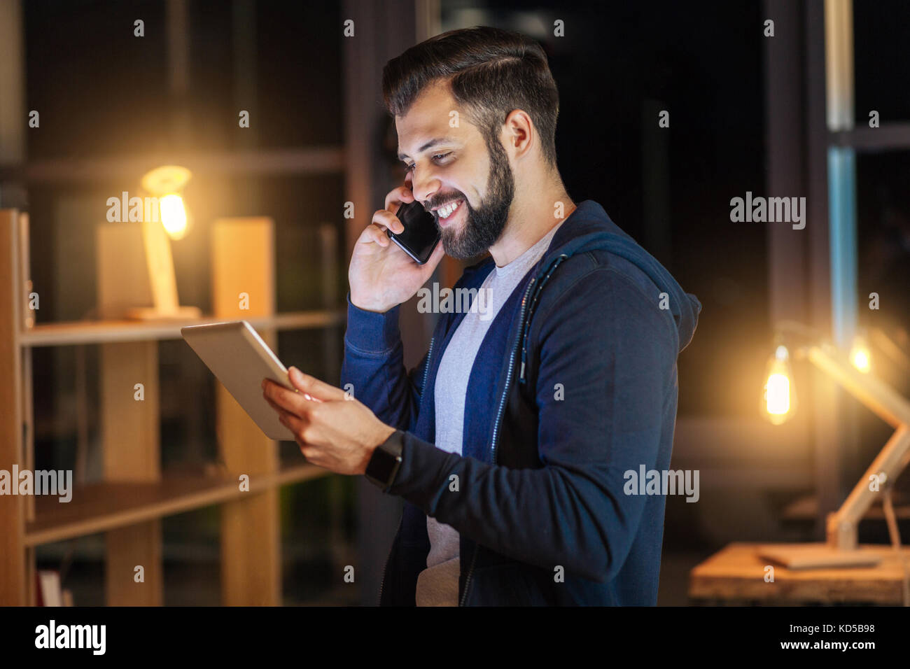 Delighted man holding his gadget Stock Photo - Alamy
