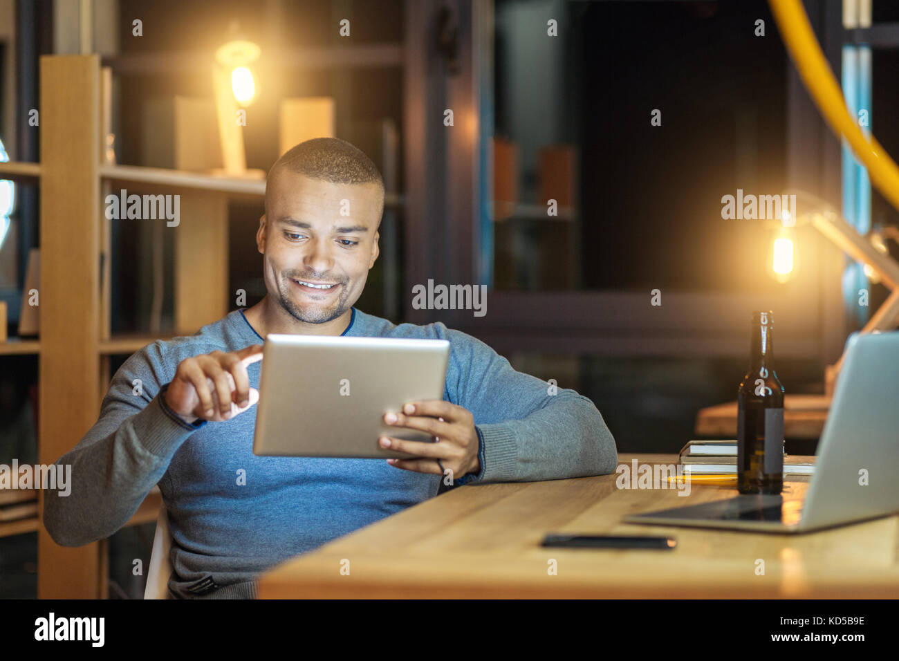 Attractive office worker using his device Stock Photo - Alamy