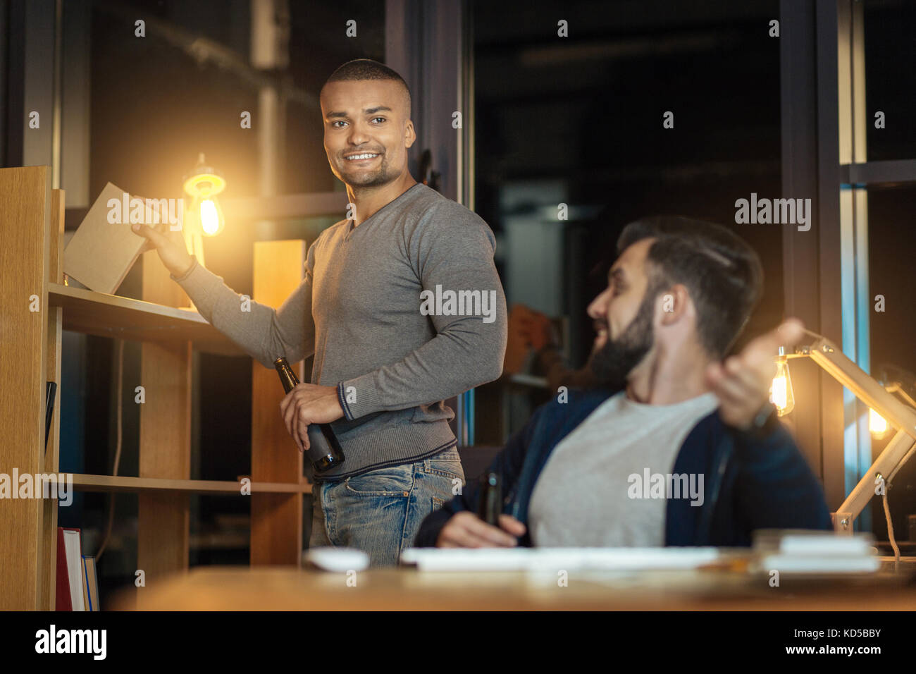 Relaxed male talking to his colleague Stock Photo - Alamy