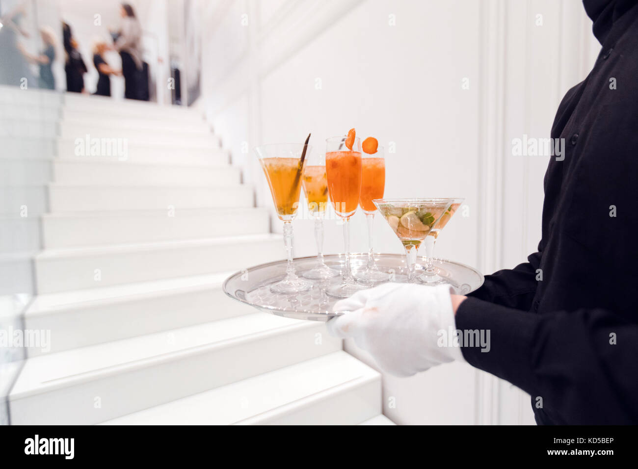 Crop waiter with drinks on tray on a white background Stock Photo - Alamy