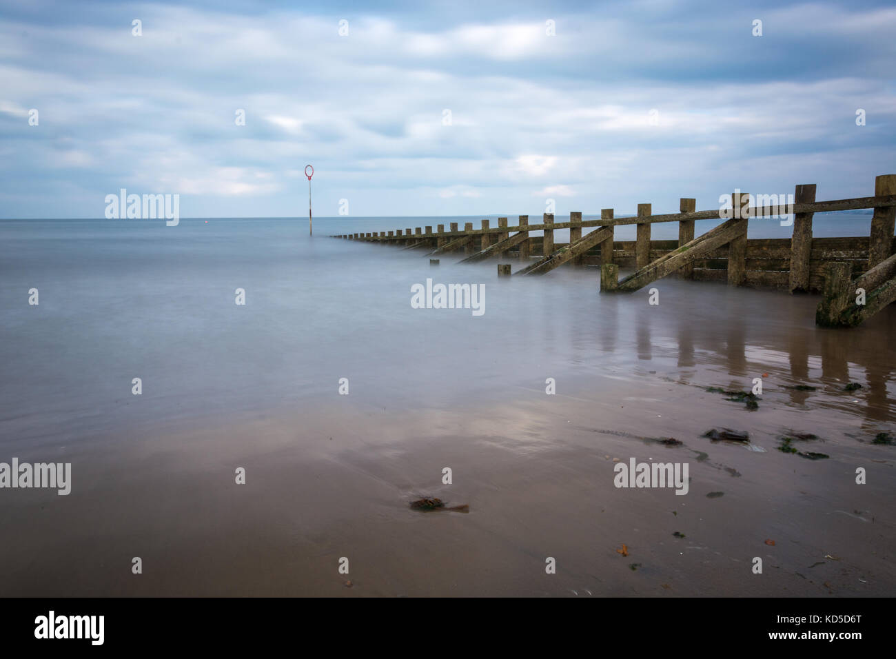 Long exposure at Portobello beach with groynes and a calm sea and ...