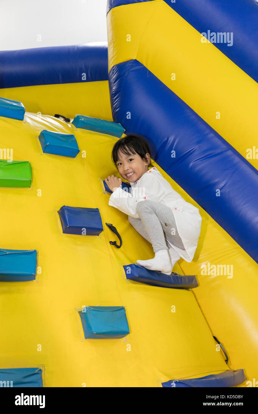Asian Little Chinese Girl climbing up ramp at Indoor Playground Stock ...