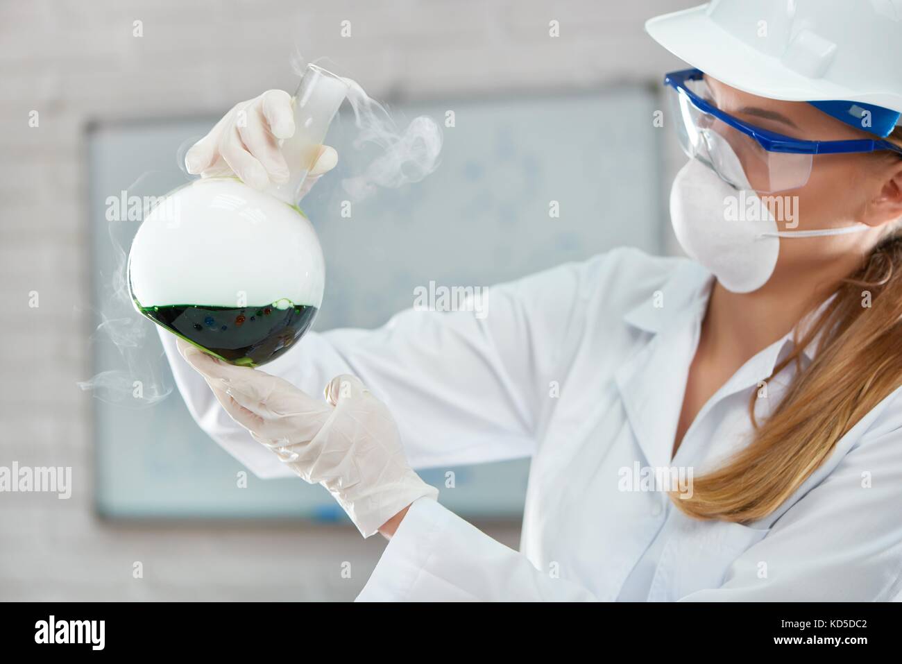 Close up of a female scientist holding liquid chemical samples while ...