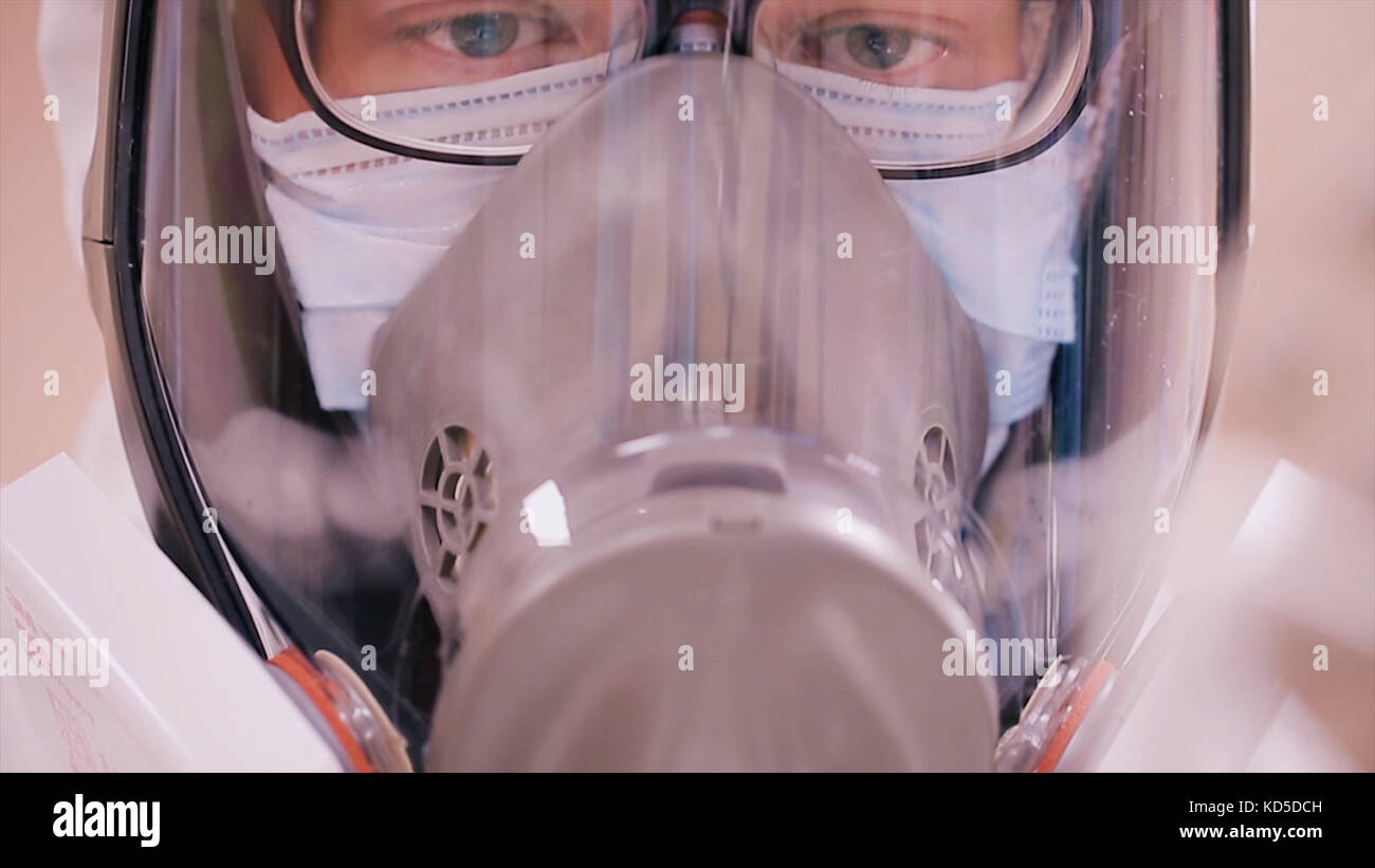 Scientist in protective clothing with respirator. Infection control ...