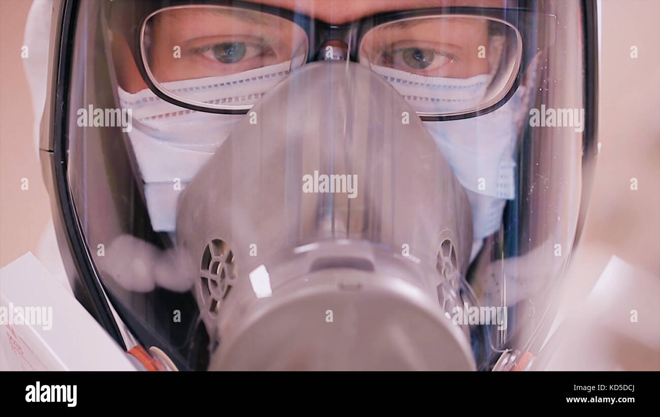 Scientist in protective clothing with respirator. Infection control ...