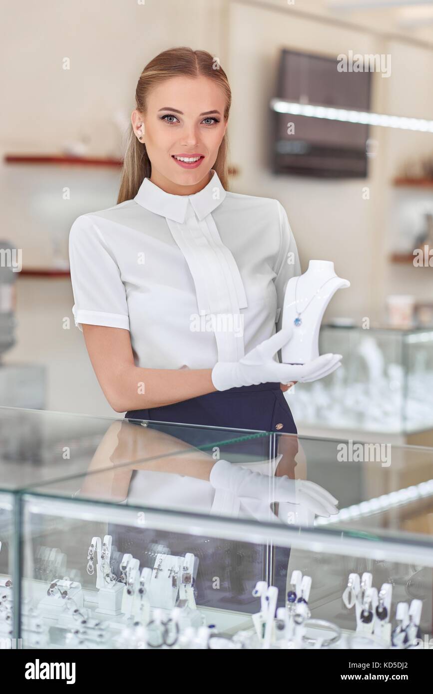 Vertial portrait of a beautiful young woman jewellery store clerk at ...