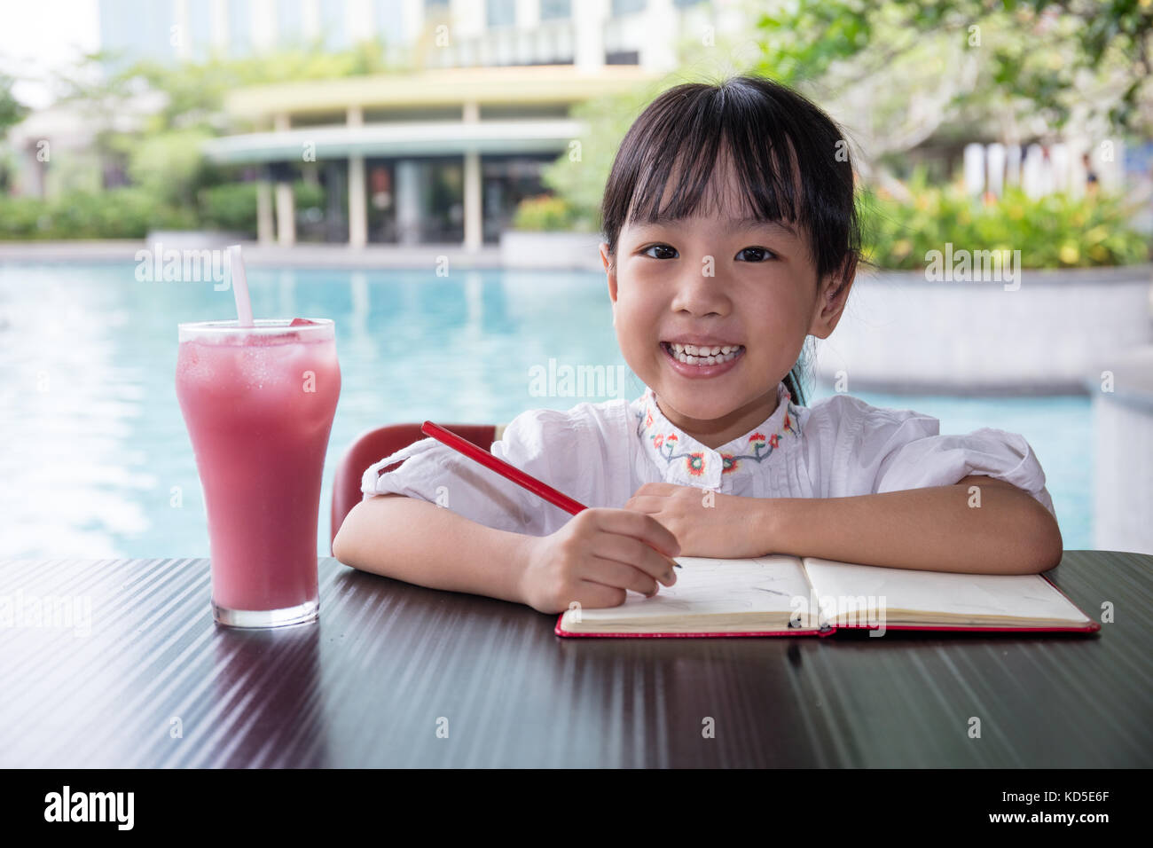 Asian Chinese little girl doing homework at outdoor cafe Stock Photo ...