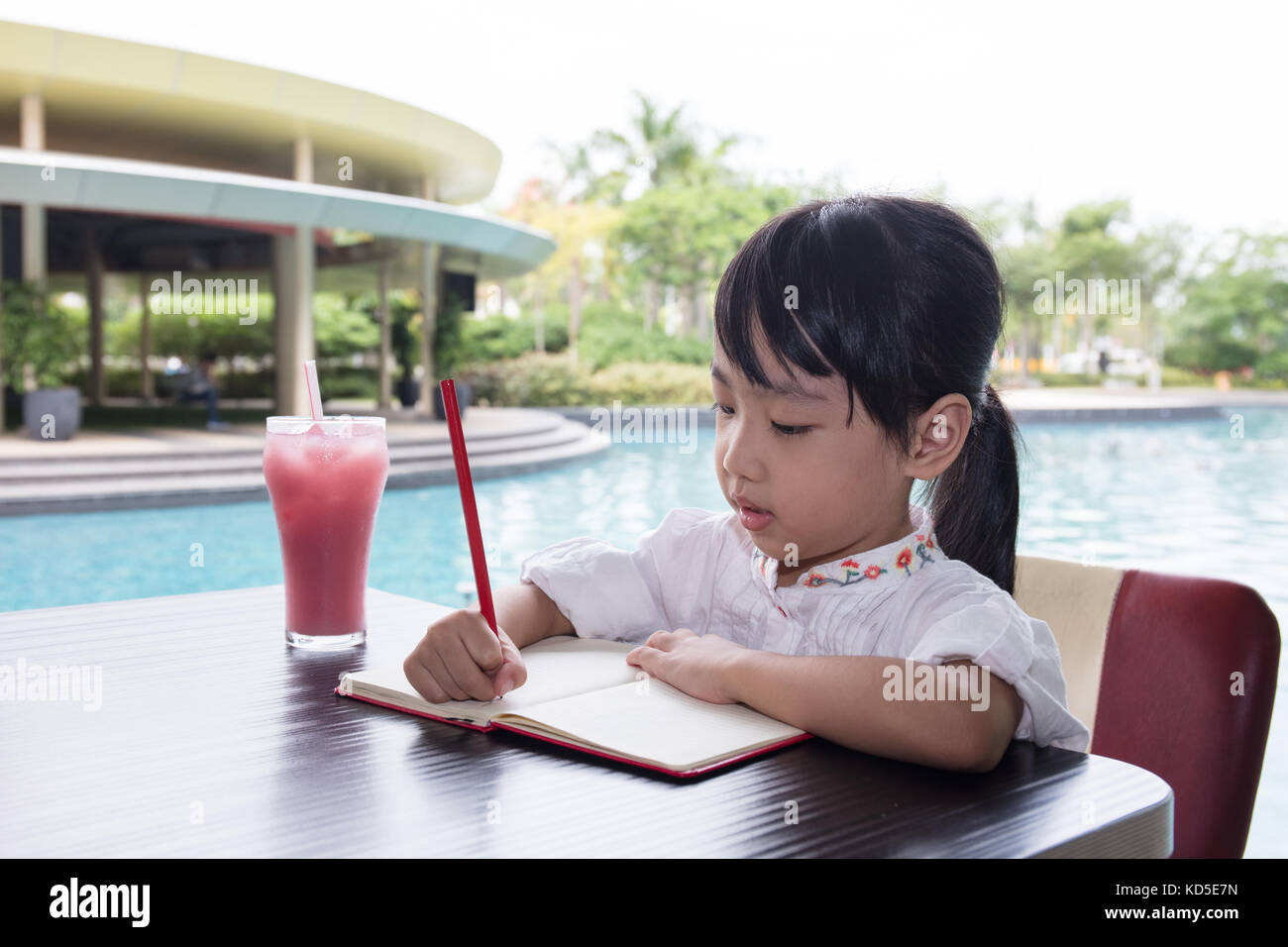 Asian Chinese little girl doing homework at outdoor cafe Stock Photo ...
