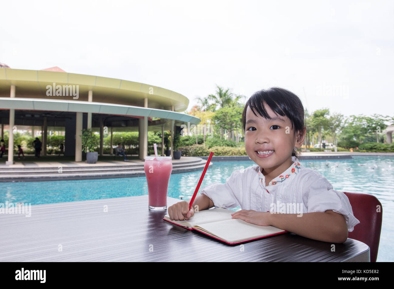 Asian Chinese little girl doing homework at outdoor cafe Stock Photo ...