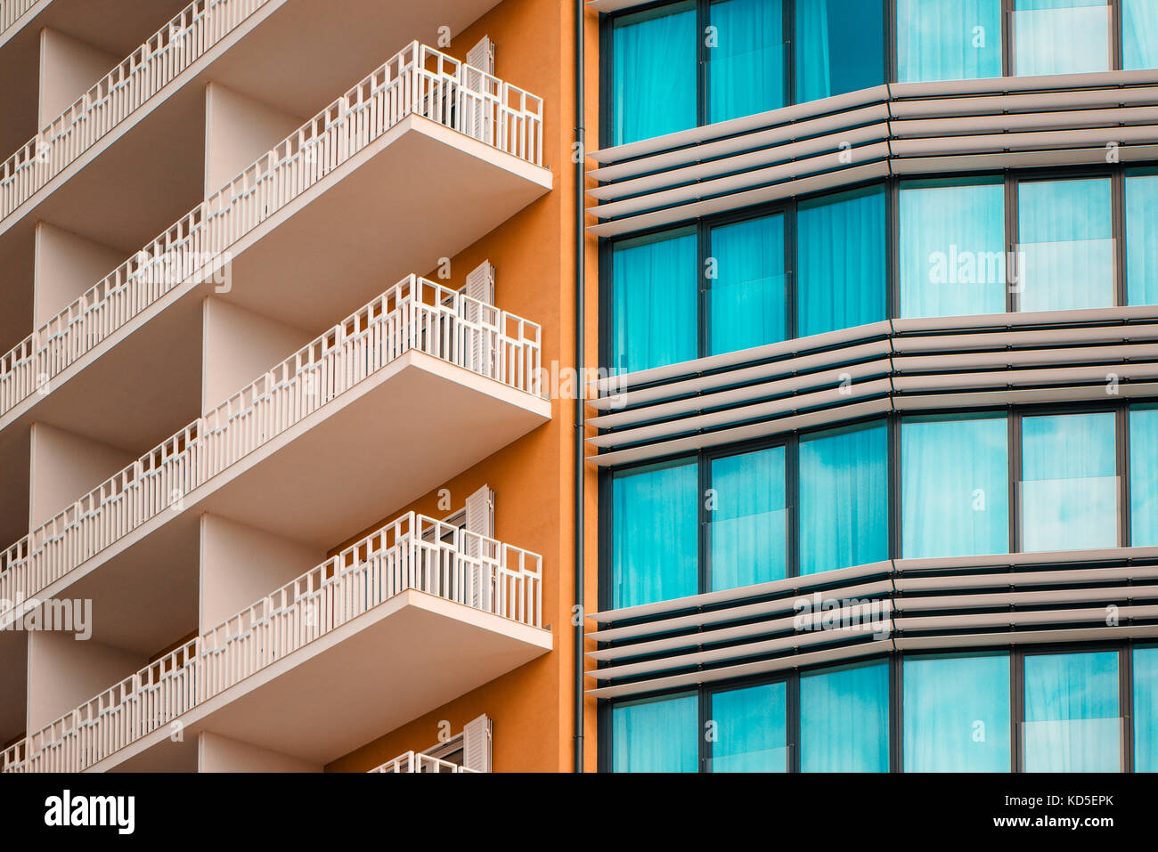 Orange and teal modern building facade with glass windows Stock Photo ...