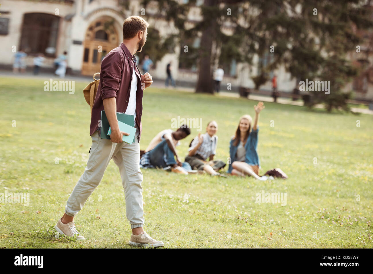 student with books looking at classmates Stock Photo - Alamy