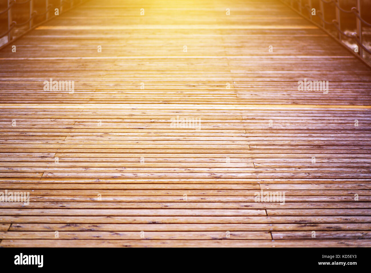 Sunset sunlight on wooden pier boardwalk at the seaside as vanishing ...