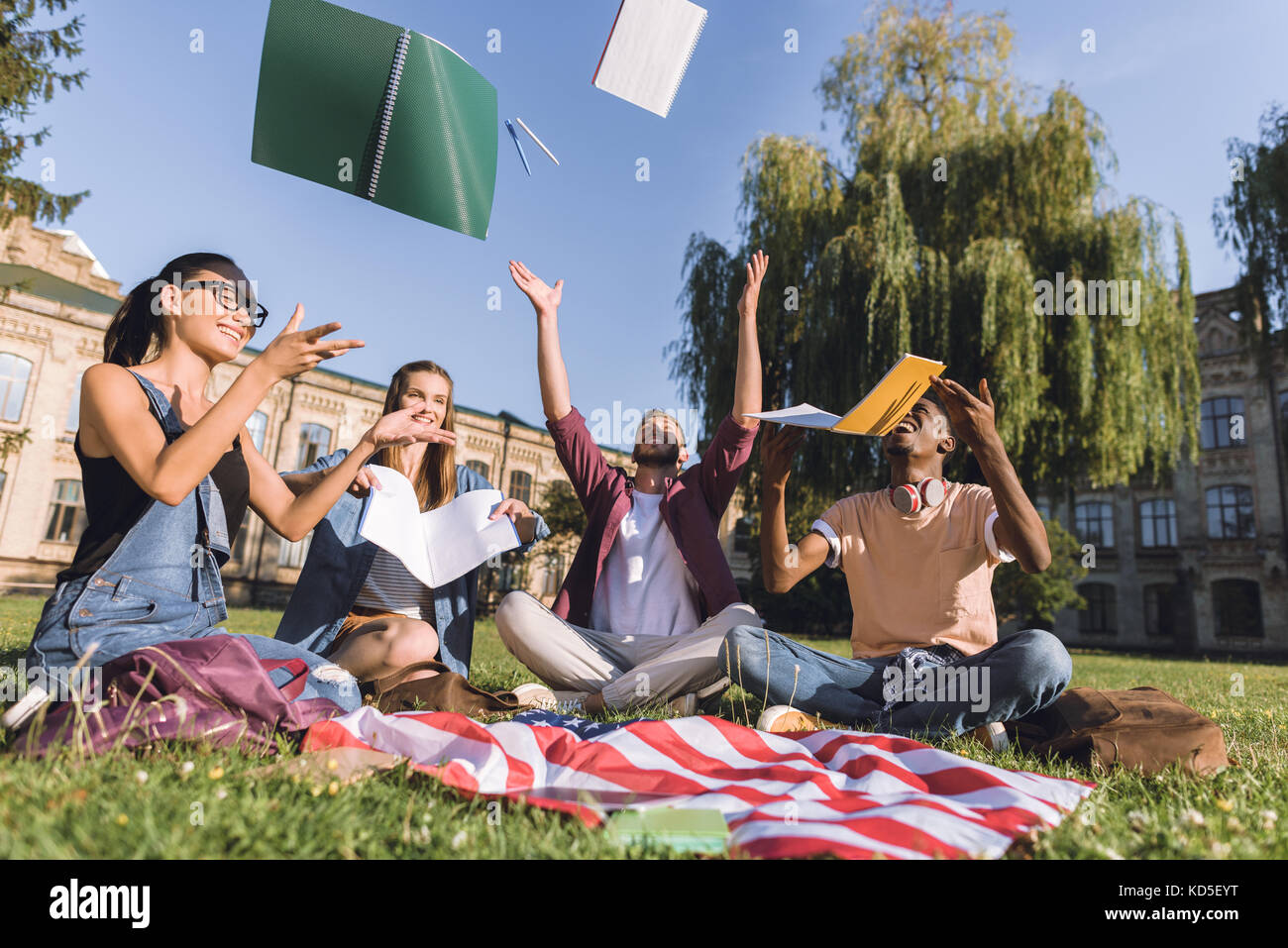 multiethnic students throwing notebooks Stock Photo - Alamy