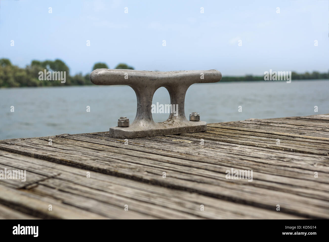 Worn old rusty mooring bollard on the river dock Stock Photo - Alamy