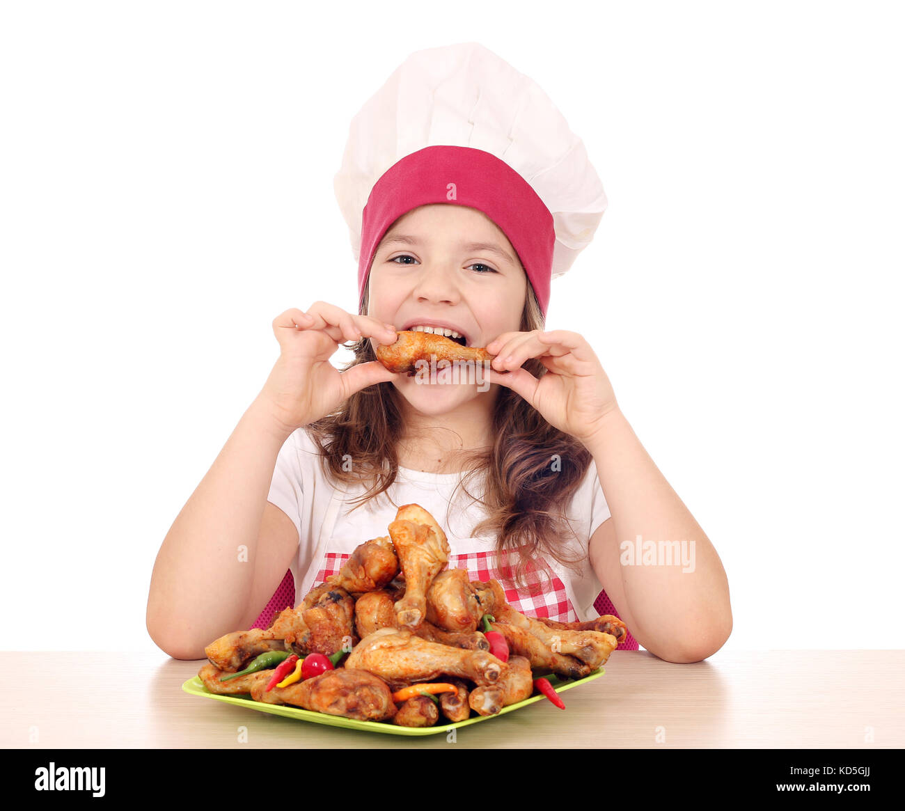 hungry little girl cook eating chicken drumstick Stock Photo - Alamy