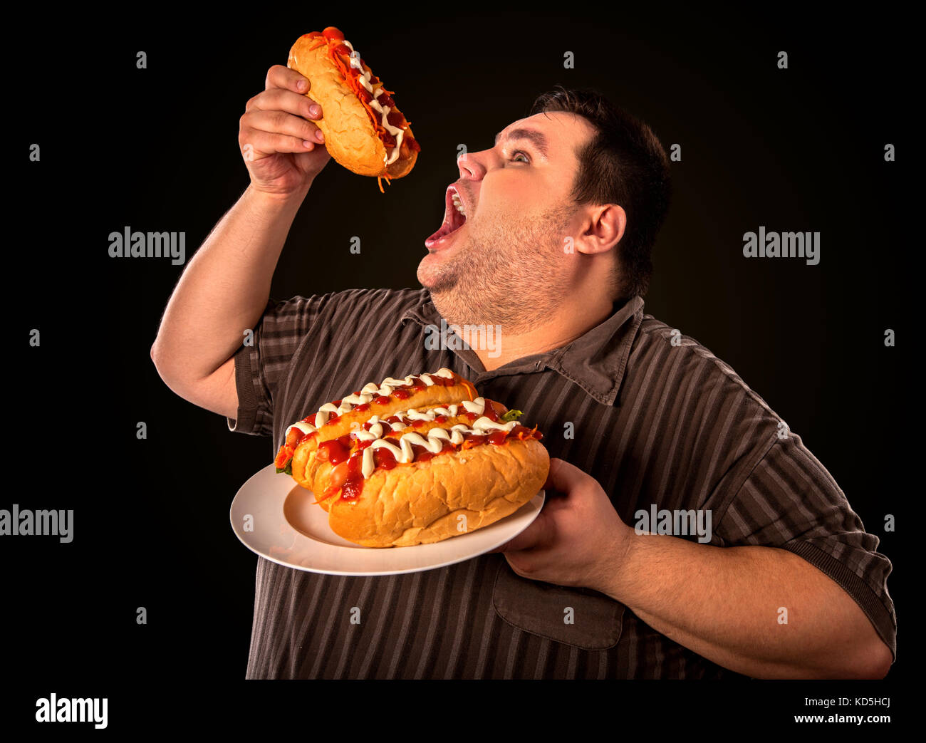 Fat man eating fast food hot dog. Breakfast for overweight person Stock ...