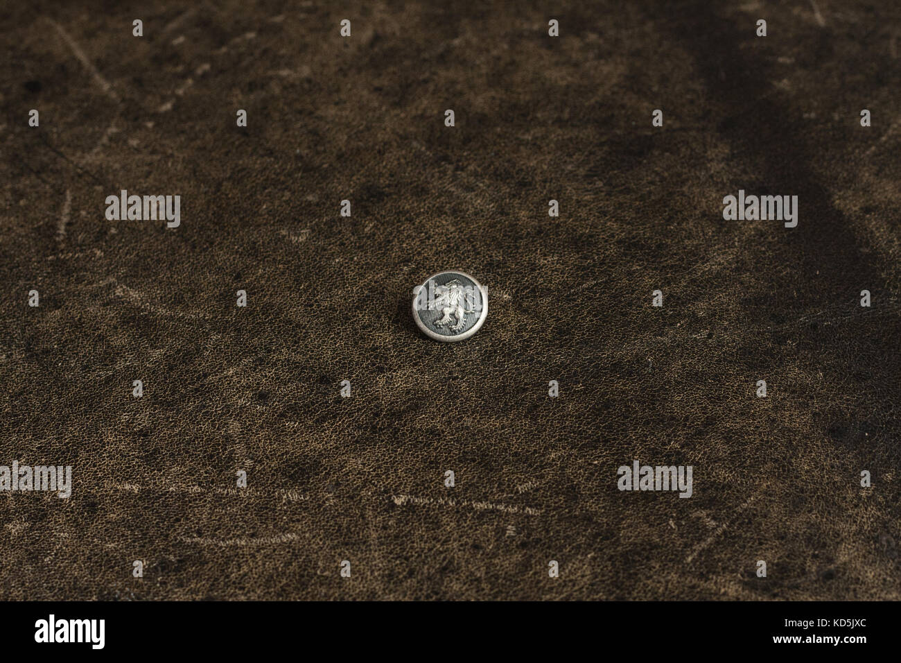 Metal button on the texture table Stock Photo - Alamy