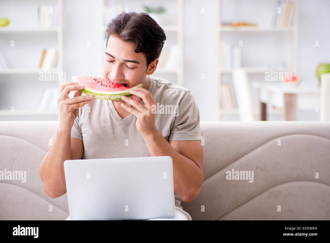 Man eating watermelon at home Stock Photo - Alamy