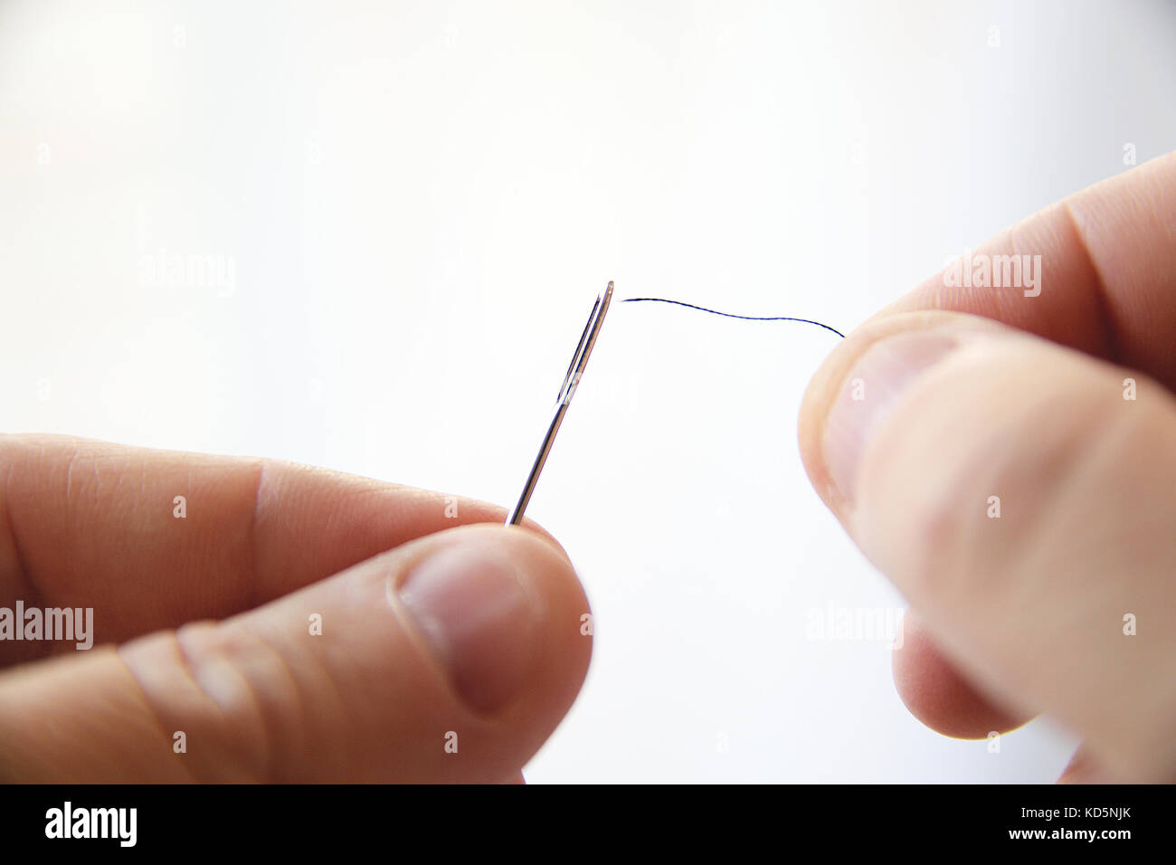 Caucasian hands threading the needle preparing to sewing. Empty copy ...