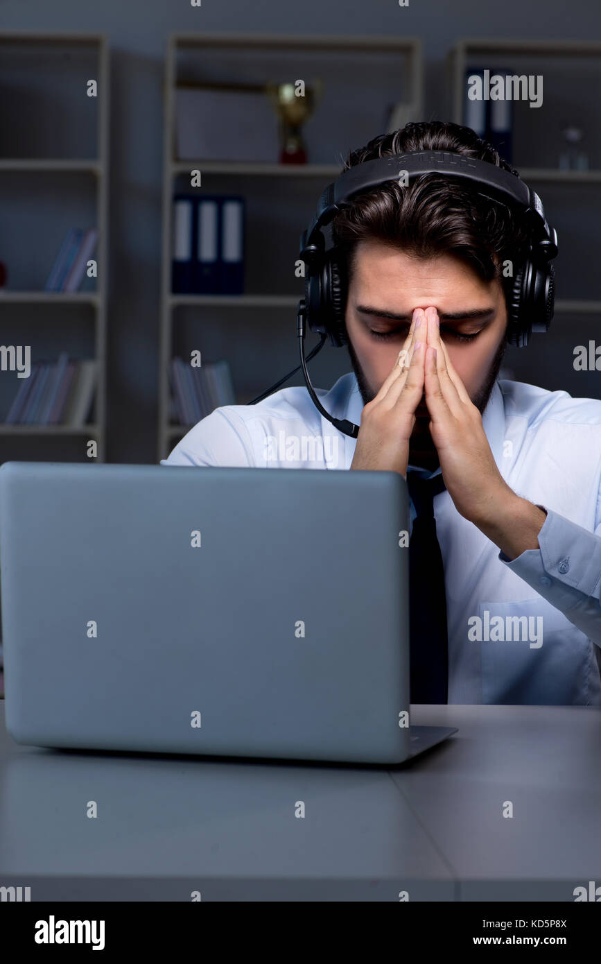 Young man in call center concept working late overtime in office Stock ...