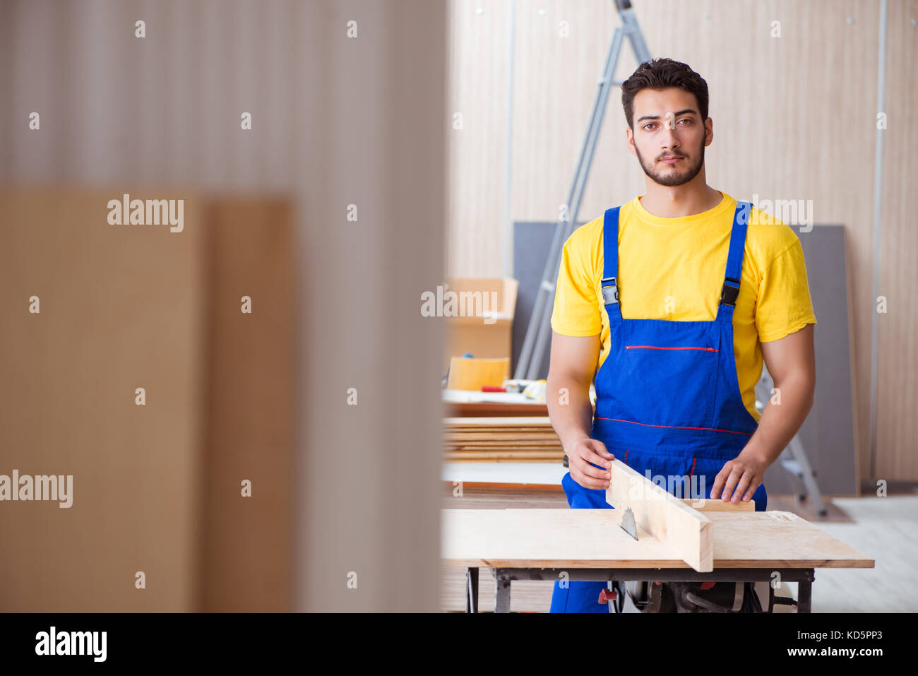 Young repairman carpenter working cutting wood Stock Photo - Alamy