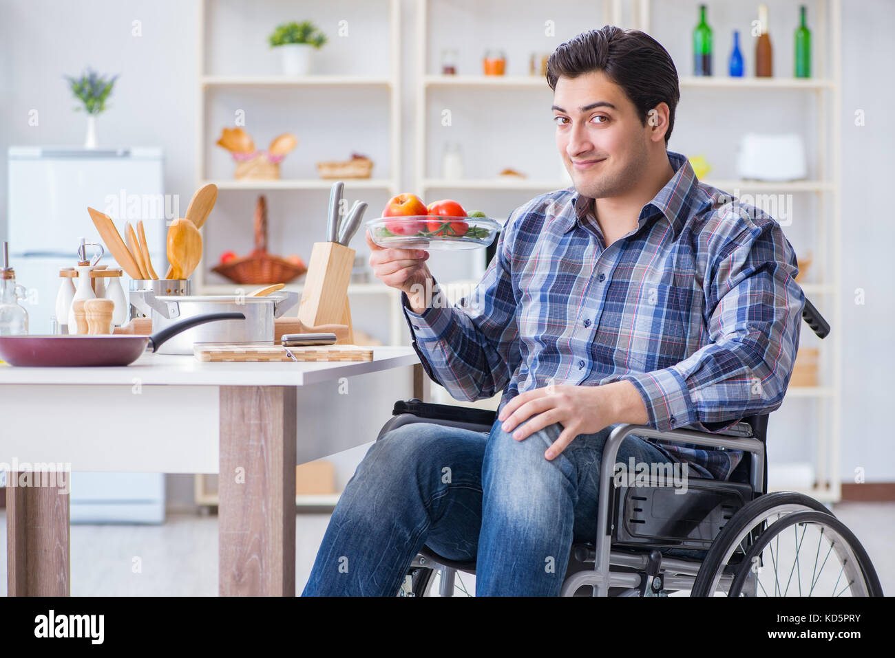 Young disabled husband preparing food salad Stock Photo - Alamy