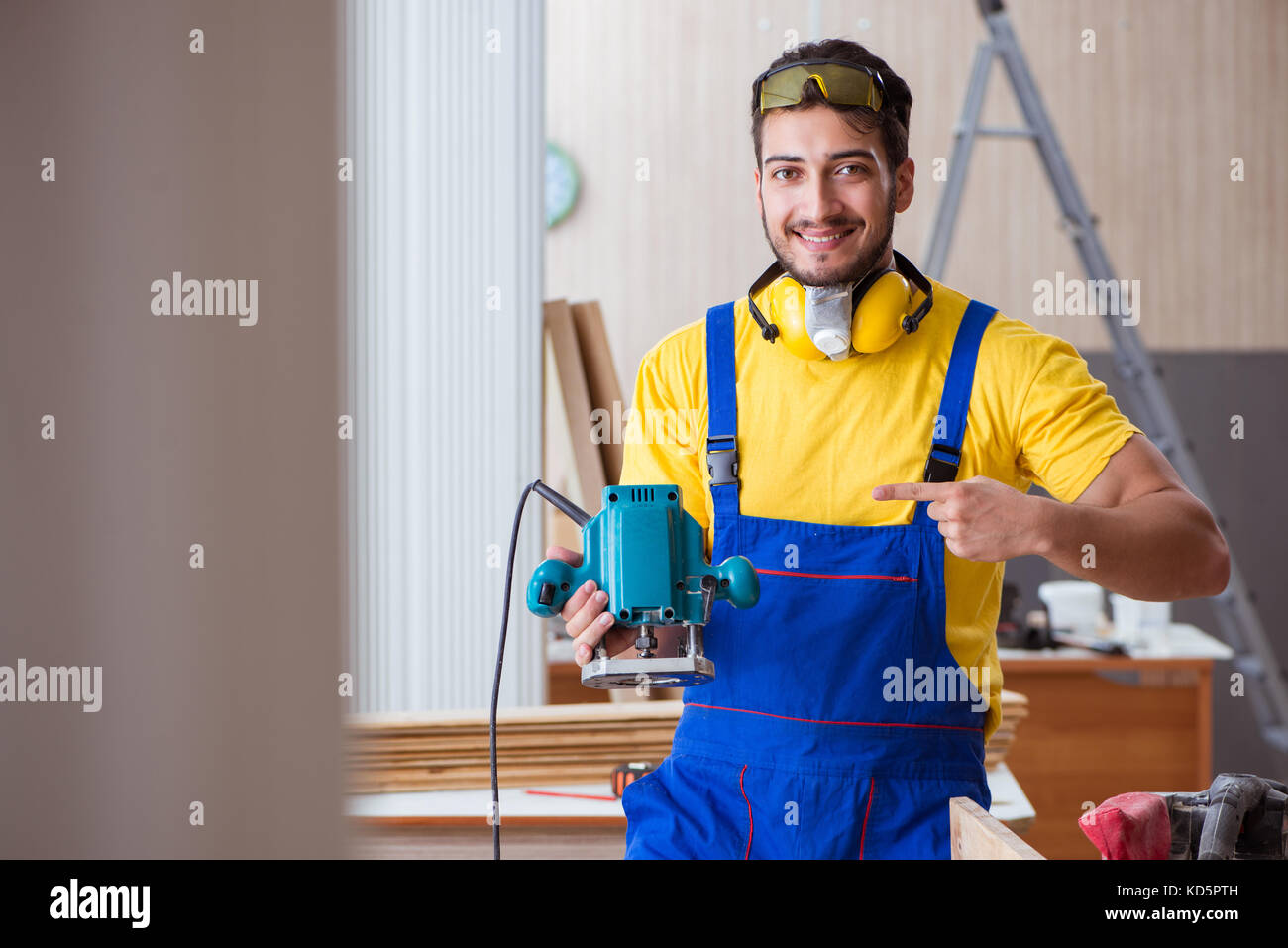 Young repairman carpenter working with power tools electric polisher ...