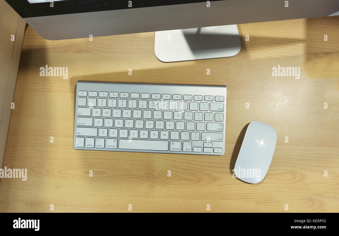 cutout silver desktop computer with mouse and keyboard on wood table ...