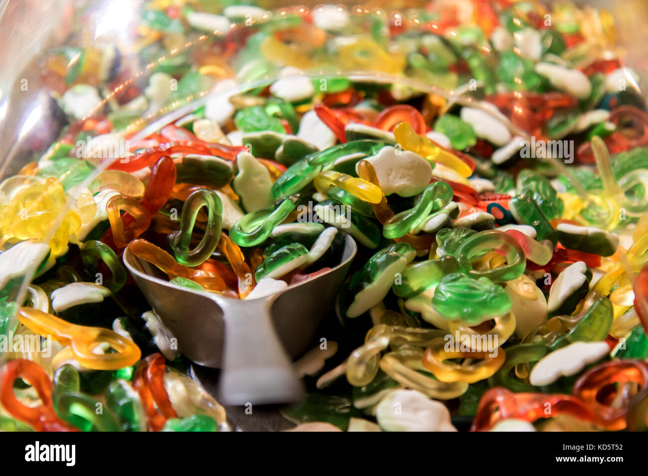 Small scoop in a plastic box with a pile of rubber candy. Offer of ...