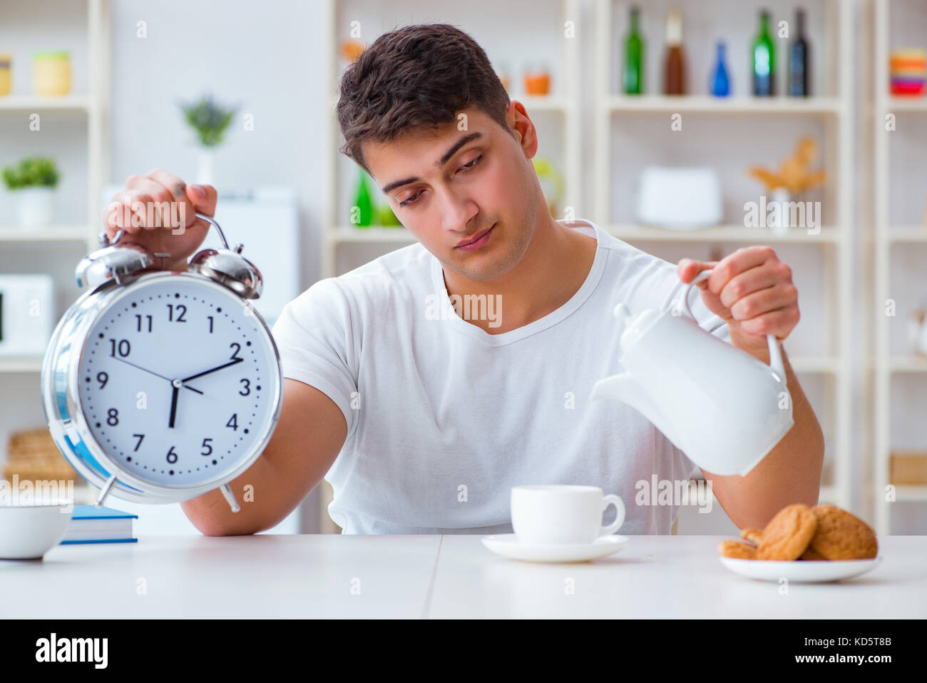Man with alarm clock falling asleep at breakfast Stock Photo - Alamy