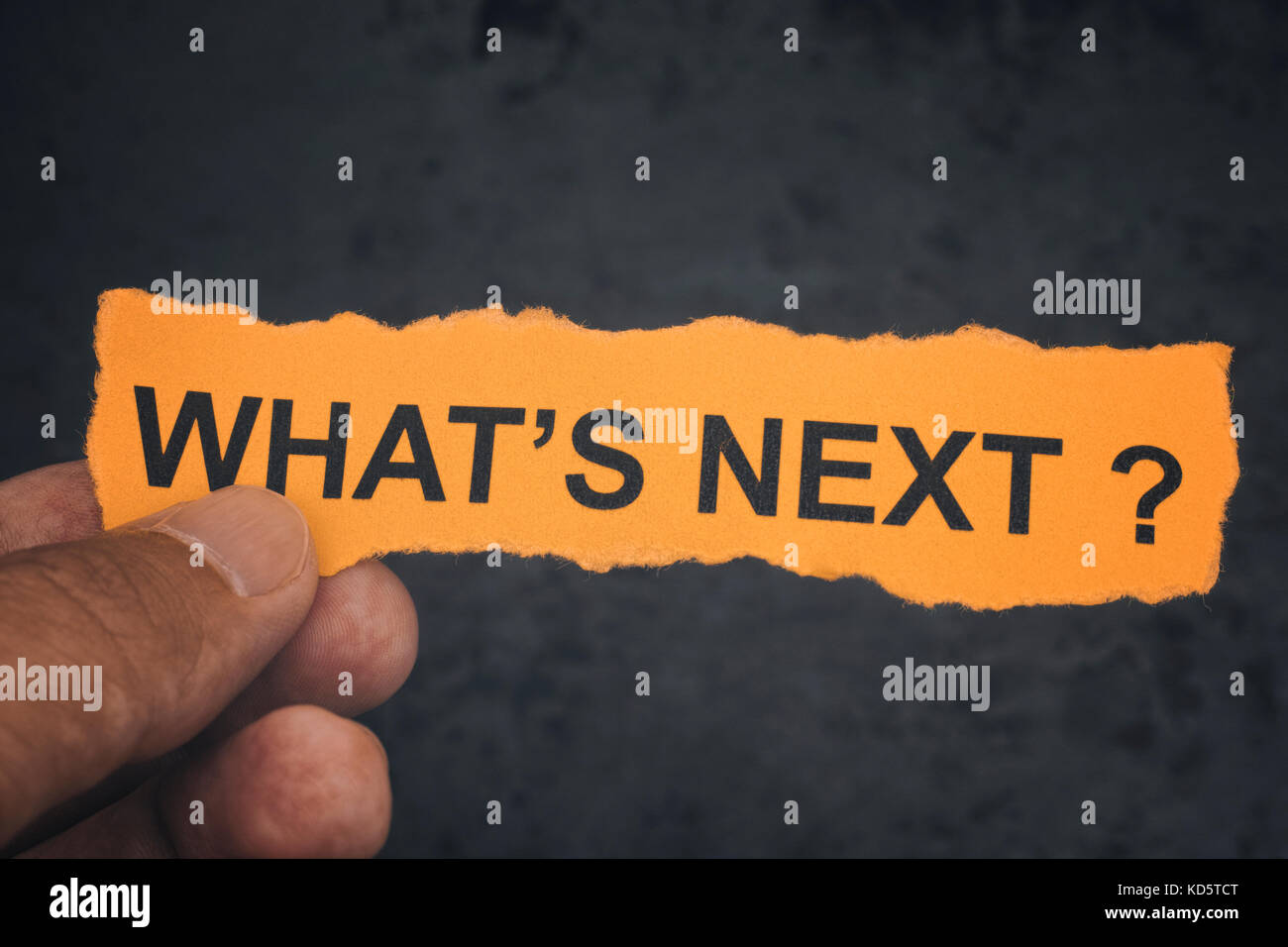 Person holds piece of paper with question What's Next in his hand ...