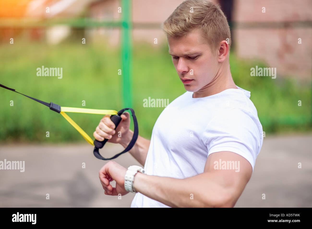 A male coach measures pulse, a city nature, in summer a T-shirt. The ...